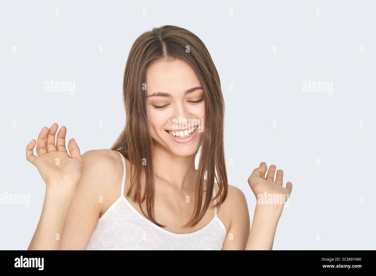 Smiling caucasian young female with long hair enjoying a happy moment ...