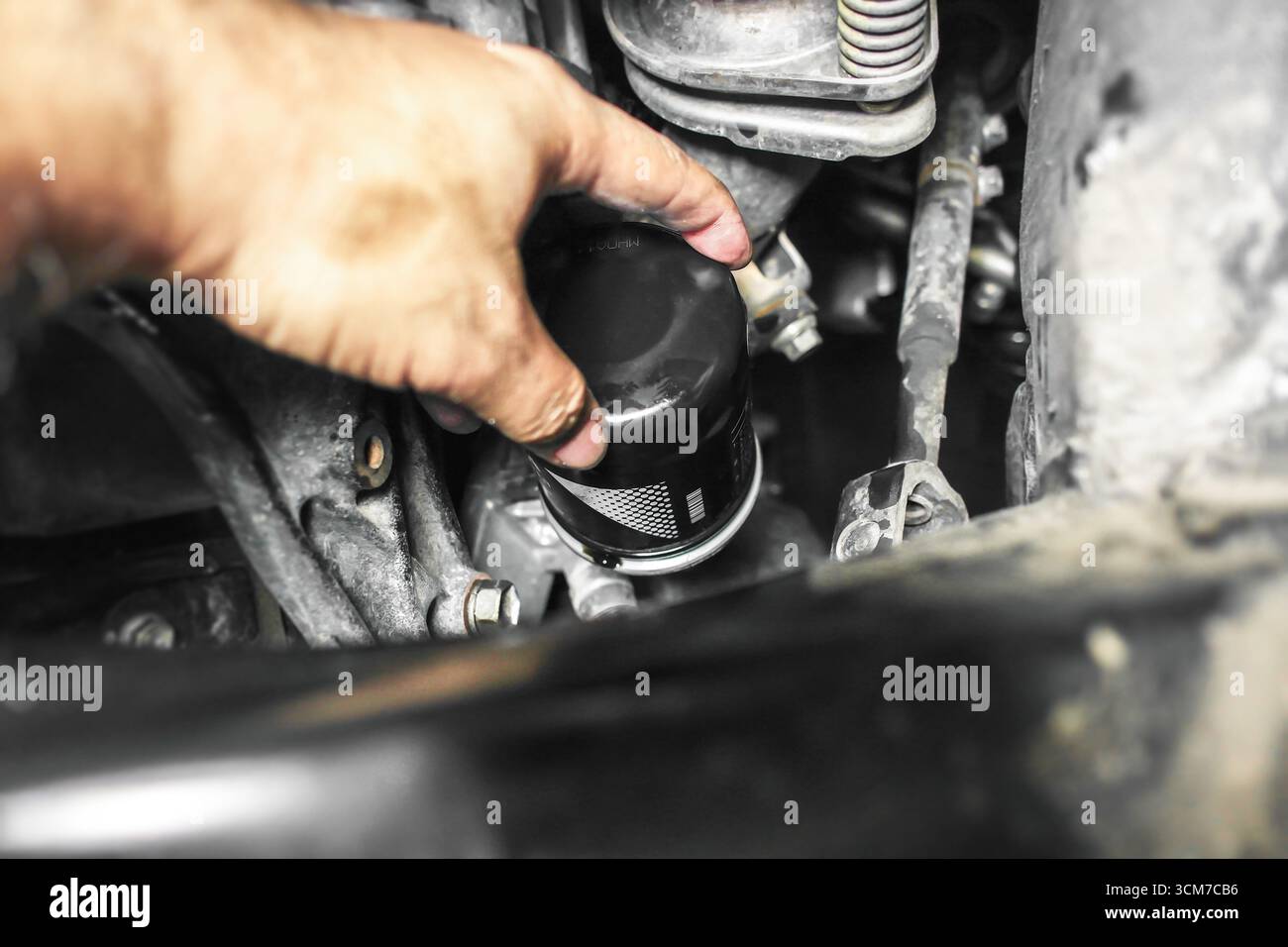 Mechanic hand replacing car oil filter inside engine compartment ...