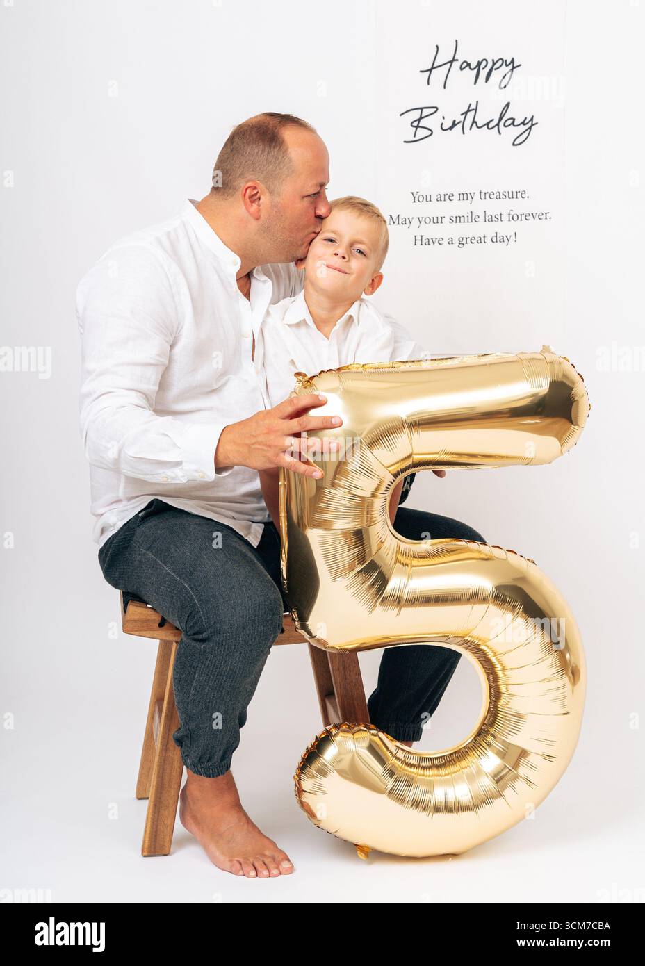 A touching moment between father and son captured during a 5th birthday celebration. The father ...