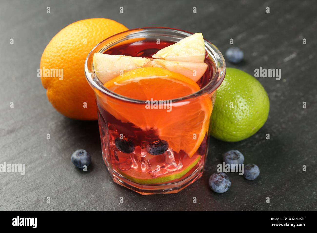 Tasty punch, fruits and berries on dark gray textured table, closeup ...