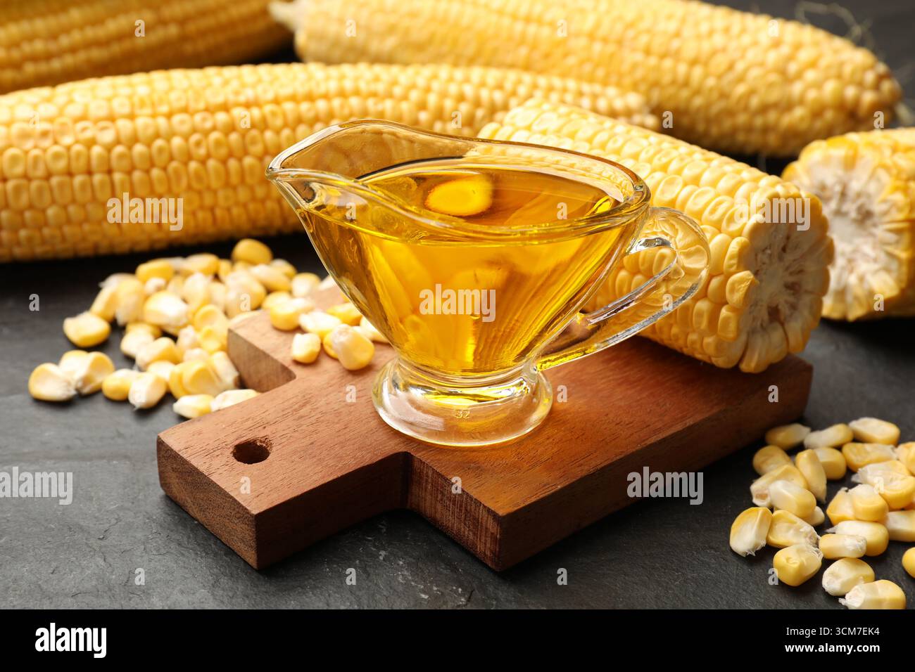 Corn oil, kernels and cobs on grey textured table, closeup Stock Photo ...