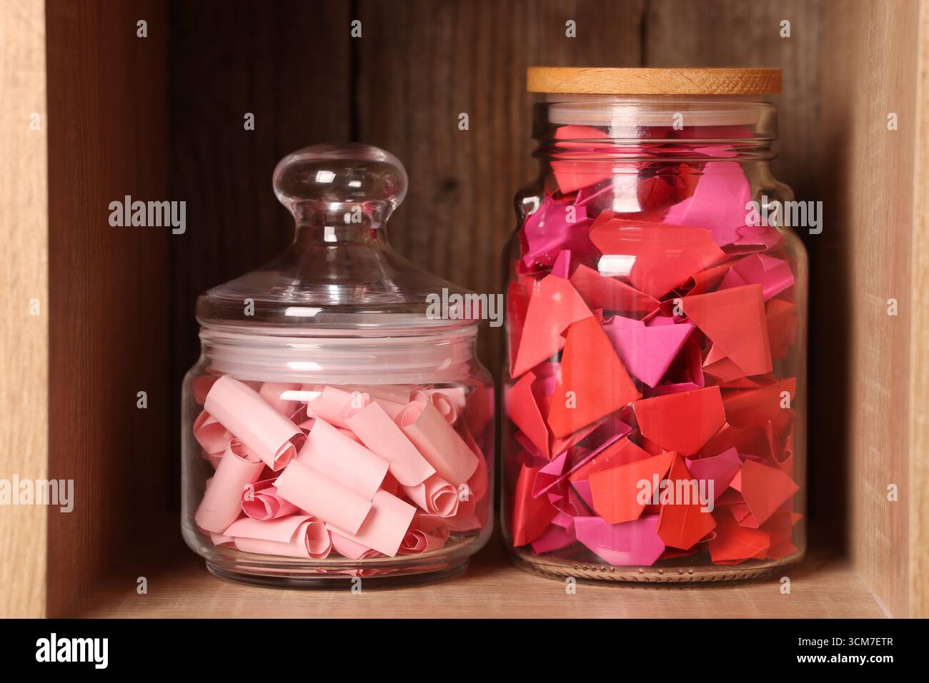 Color paper pieces in glass jars on wooden shelf Stock Photo - Alamy