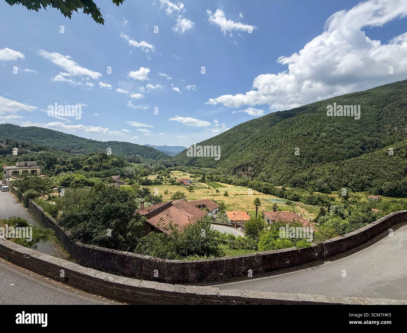 View of the surrounding steep wooded mountain slopes, and on the valley ...