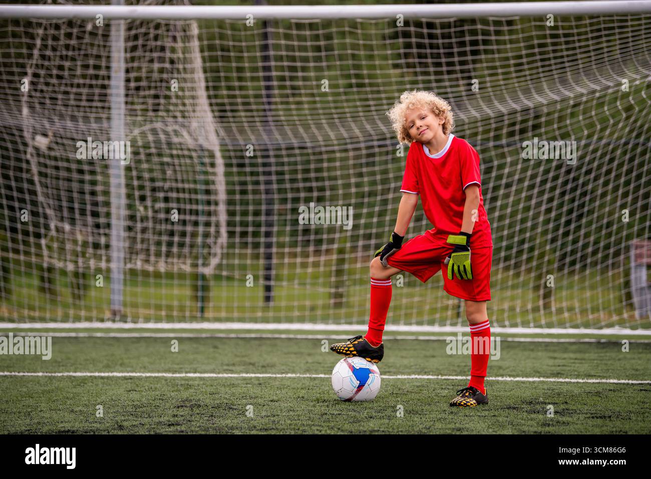 Boy football player with ball in his boot stands at the gate Stock ...