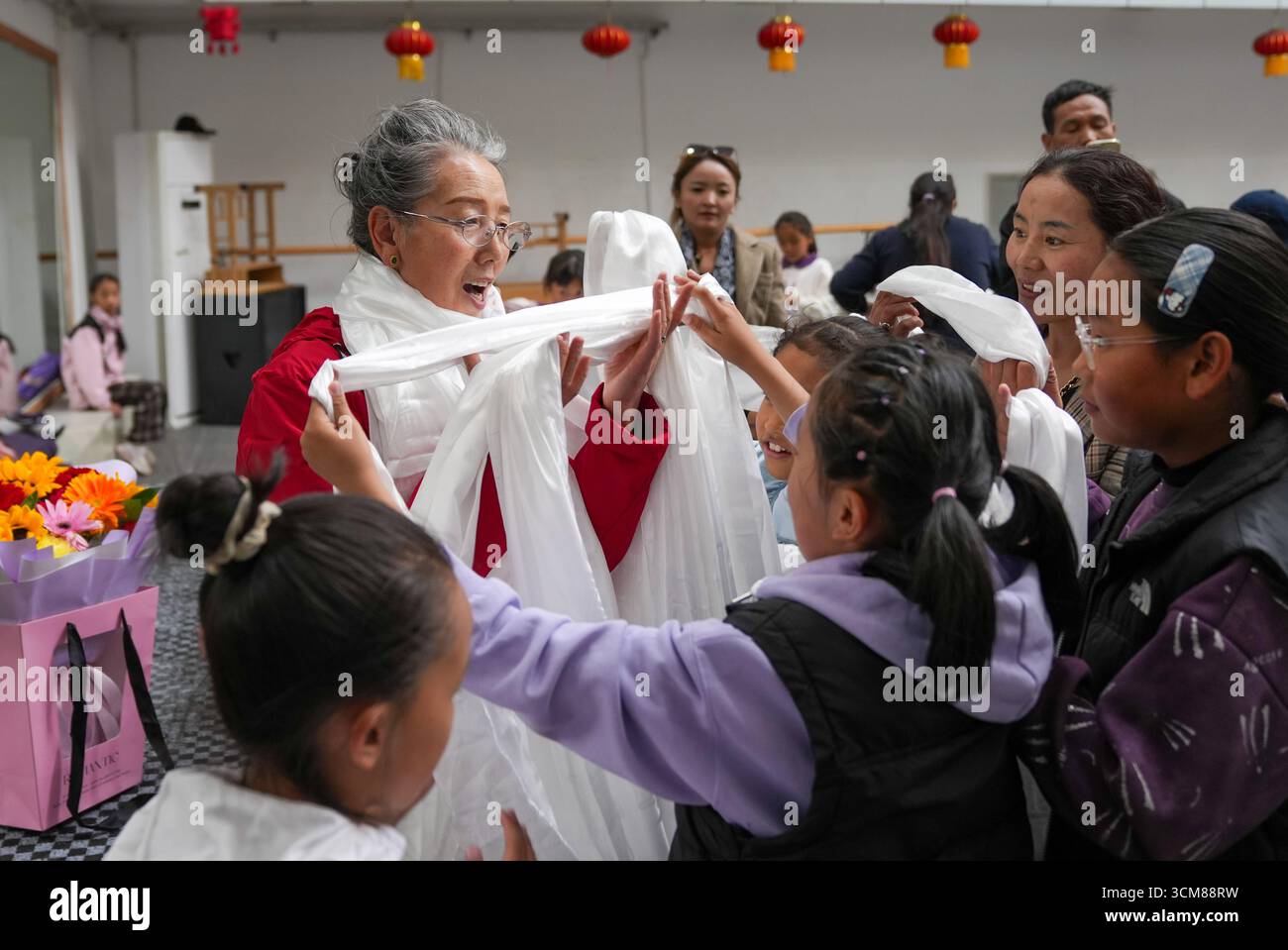 (250915) -- LHASA, Sept. 15, 2025 (Xinhua) -- Children present hada to ...