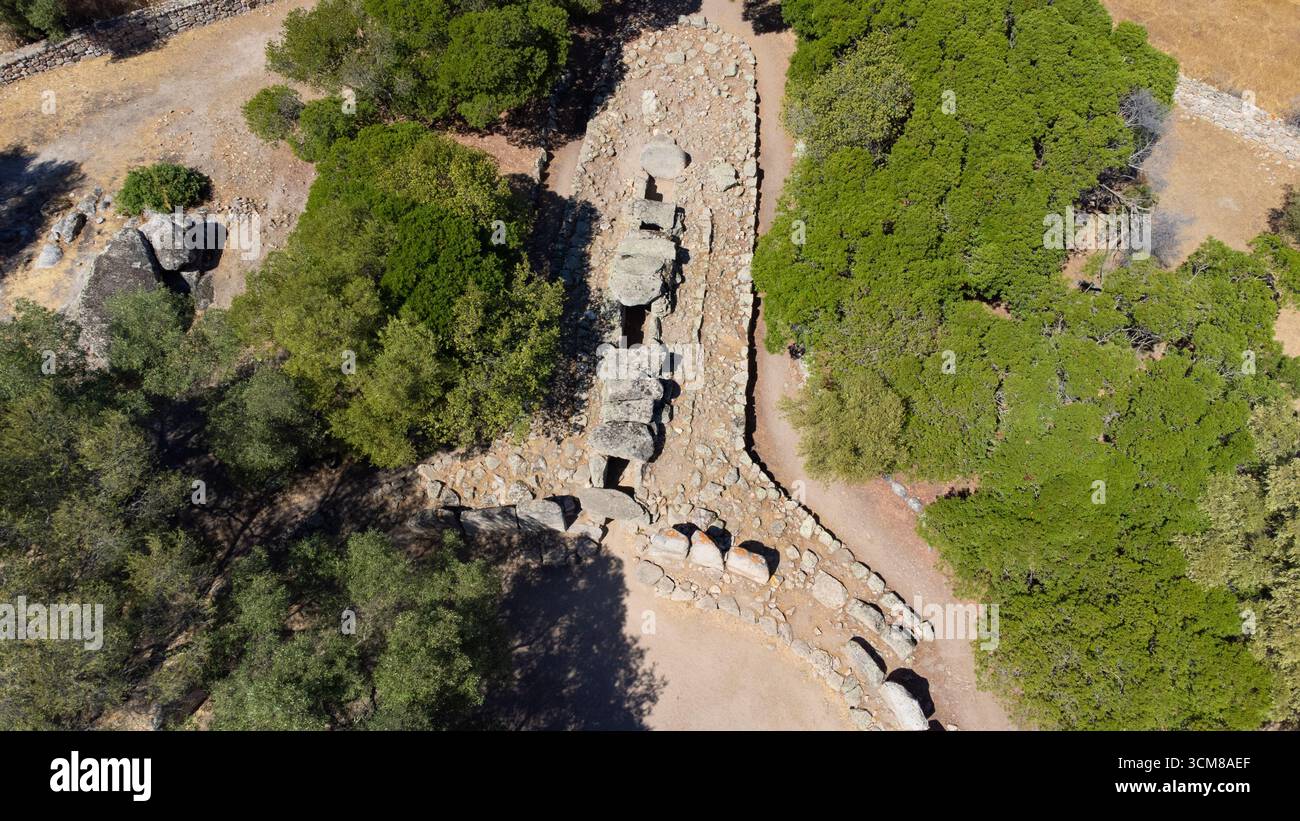 Prehistoric Giants' Tomb ruins surrounded by trees and dry landscape ...