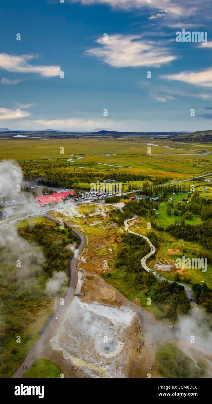 Aerial view of steaming geysers, hot springs, and a winding pathway in ...