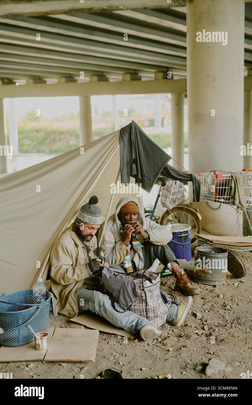 Homeless men sitting under hi-res stock photography and images - Alamy