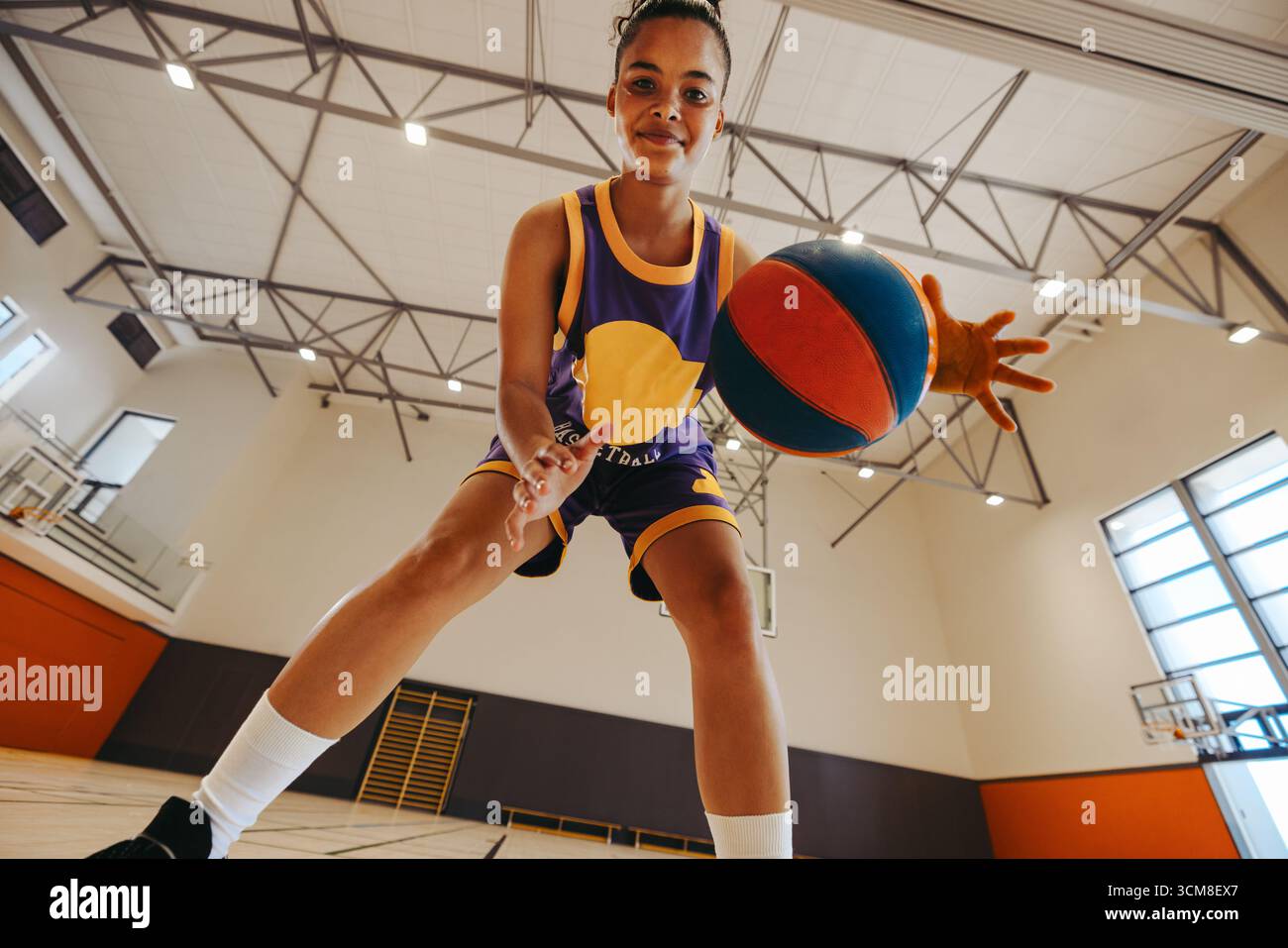A dynamic scene of a young athlete practicing basketball dribbling in a ...