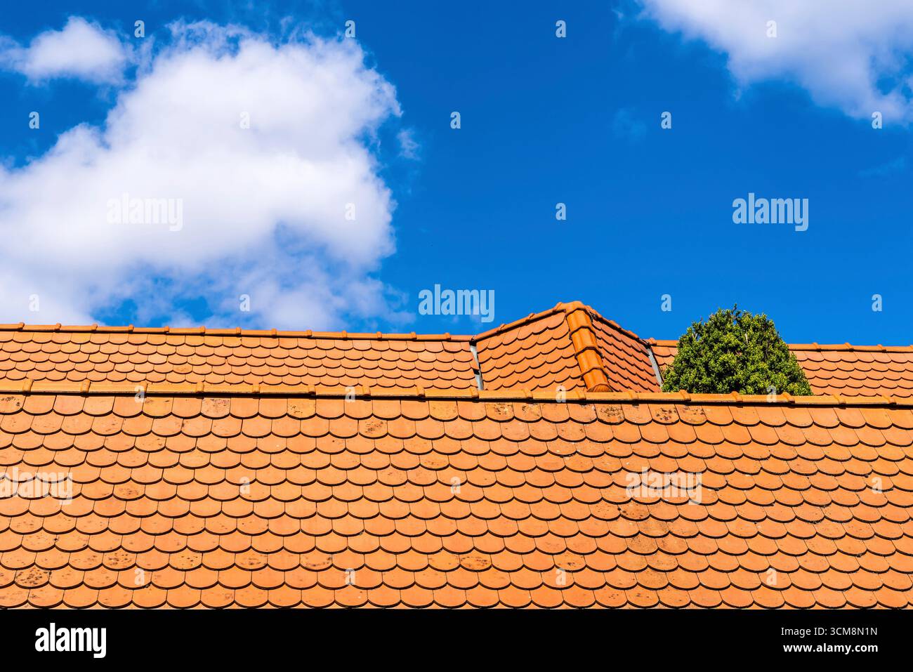 Bright red tiled roof under steel blue sky with clouds hi-res stock ...