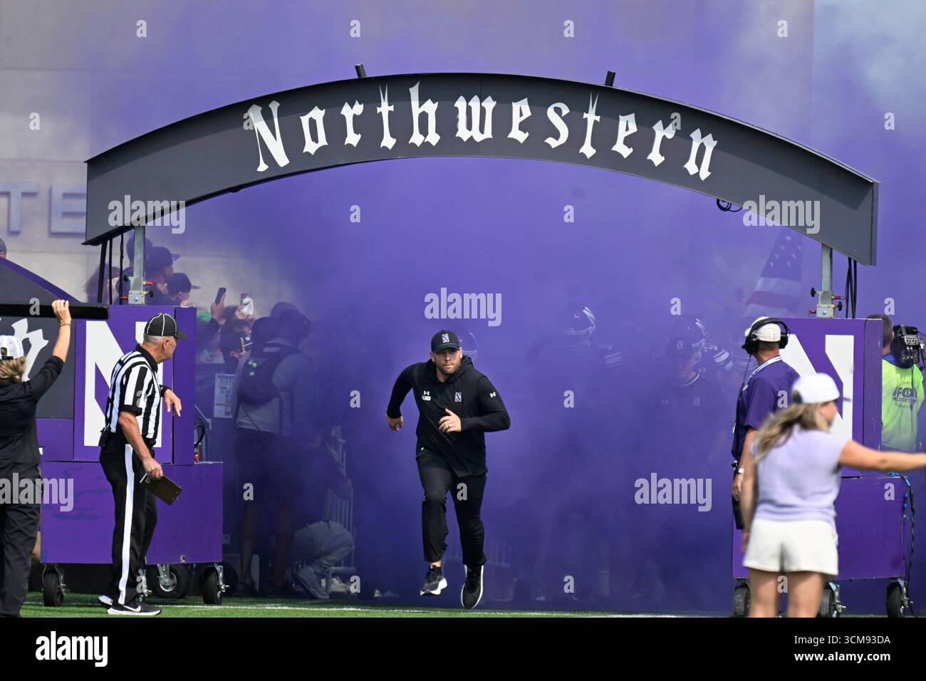 Northwestern head coach David Braun leads his team onto the field ...