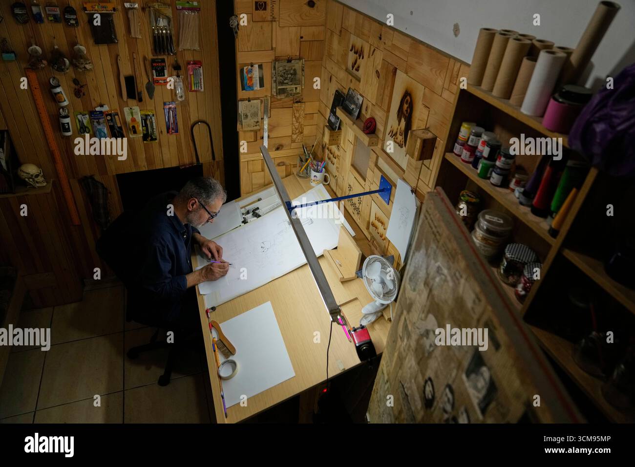Palestinian visual artist Yousef Awad, 48, works at his art studio in ...