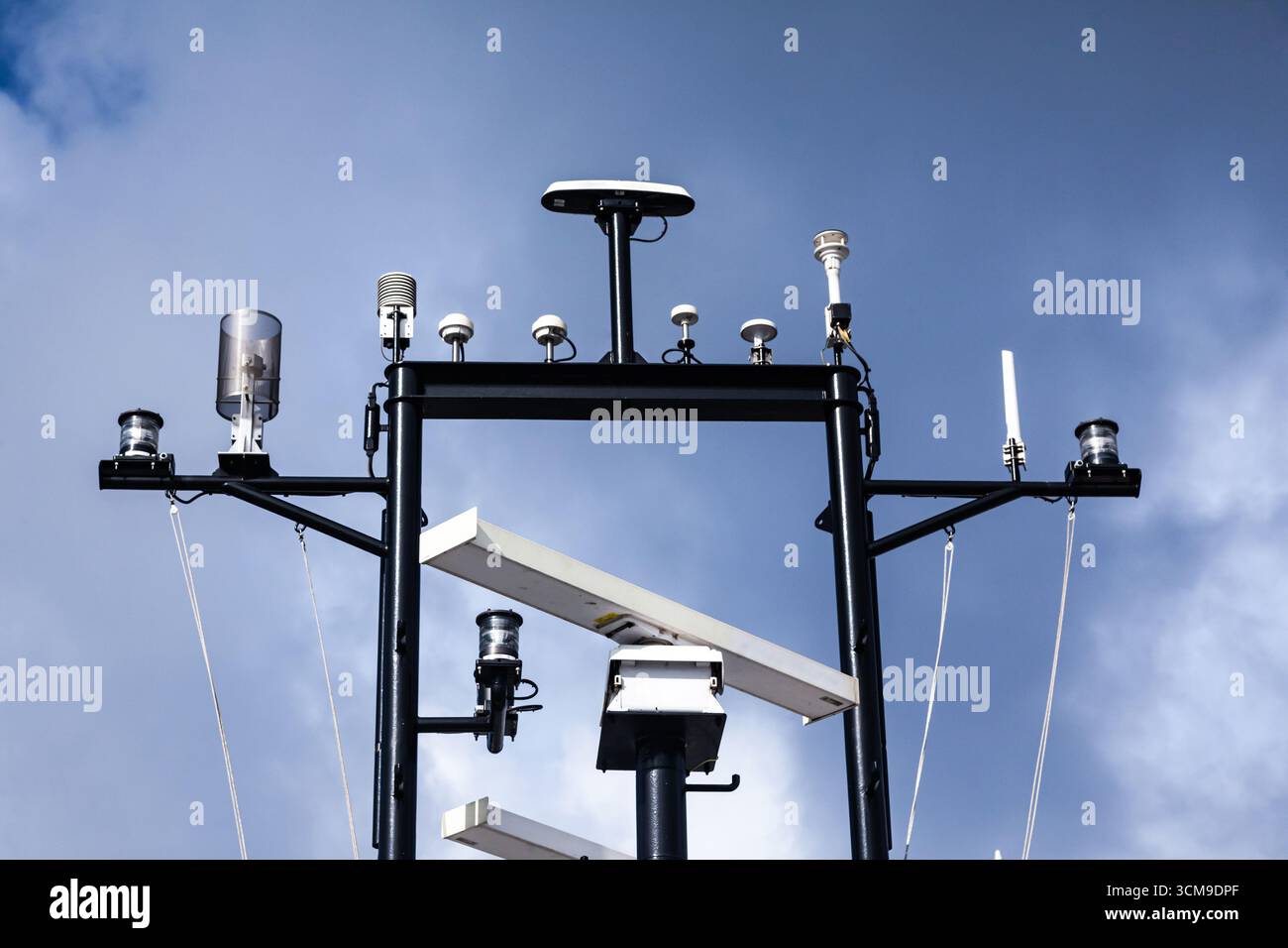 Ship's mast with navigation equipment, view from below against the sky ...