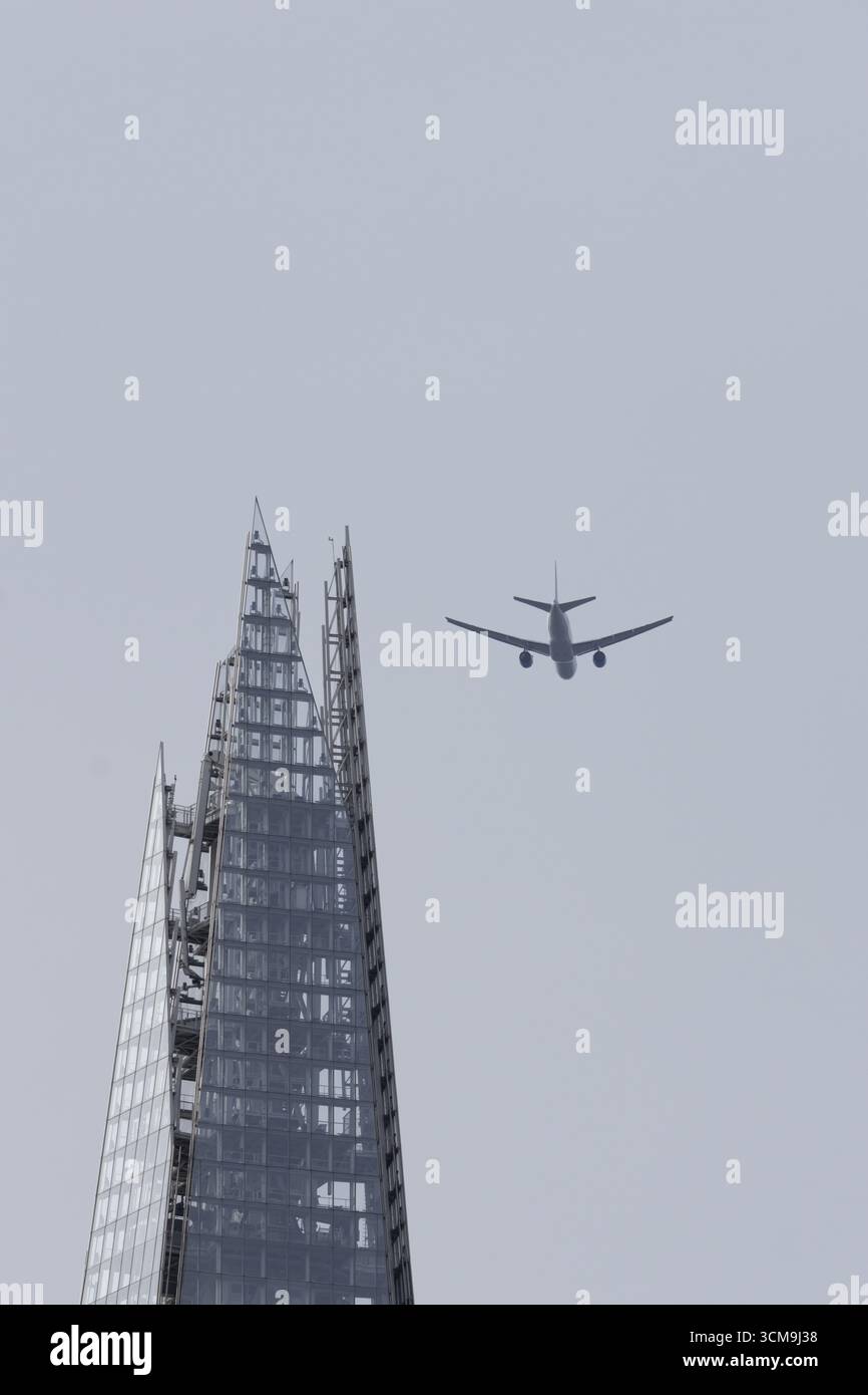 Jet passenger aircraft in flight over The Shard skyscraper building ...
