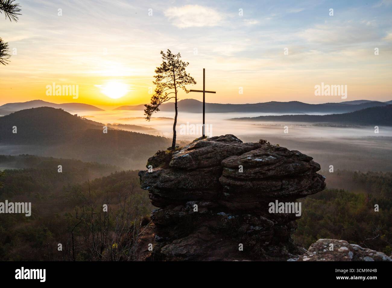 Sunrise over a mountain landscape, rising sun behind a sandstone cliff ...