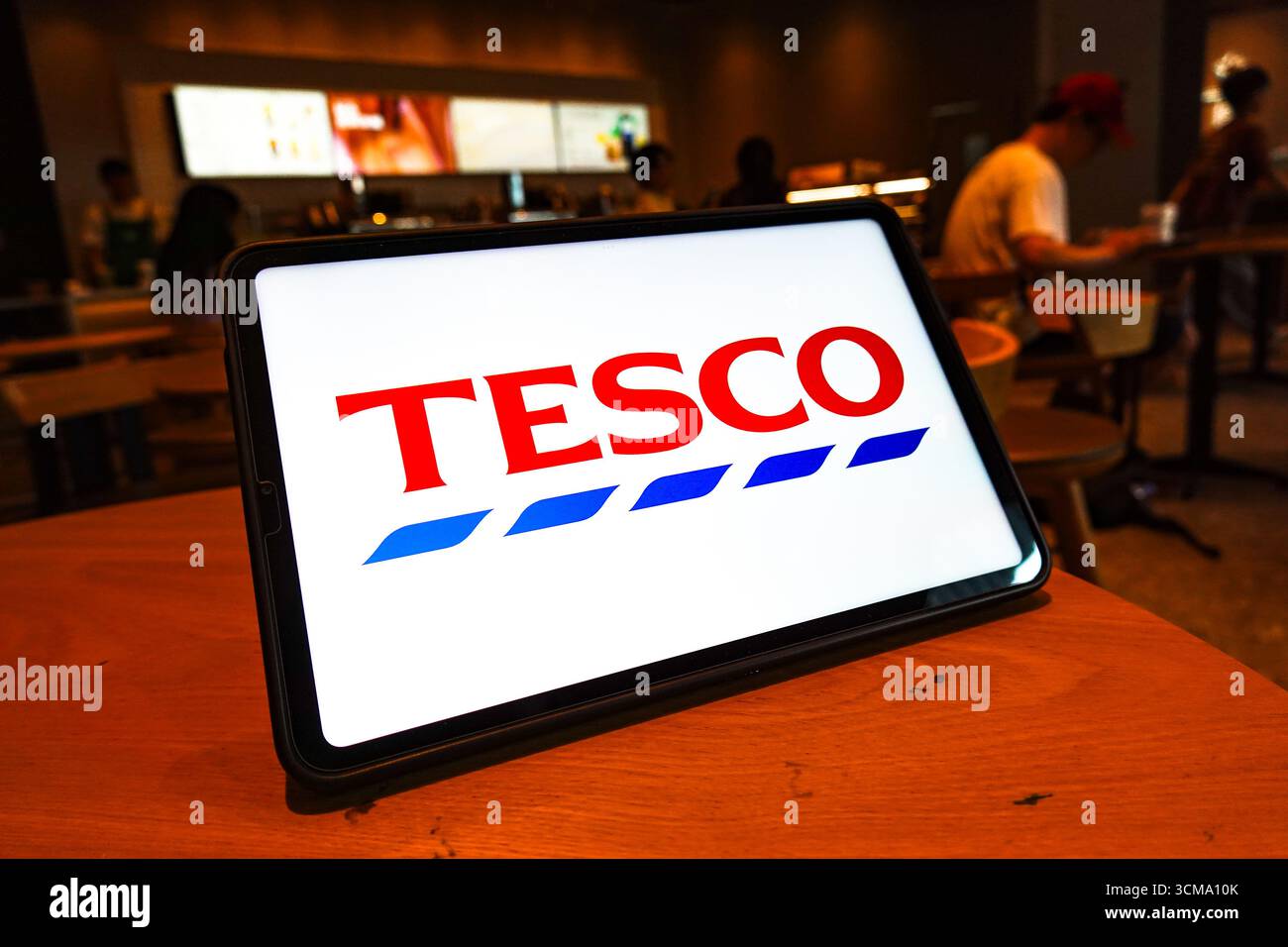 In this photo illustration, the logo of Tesco is displayed on the ...