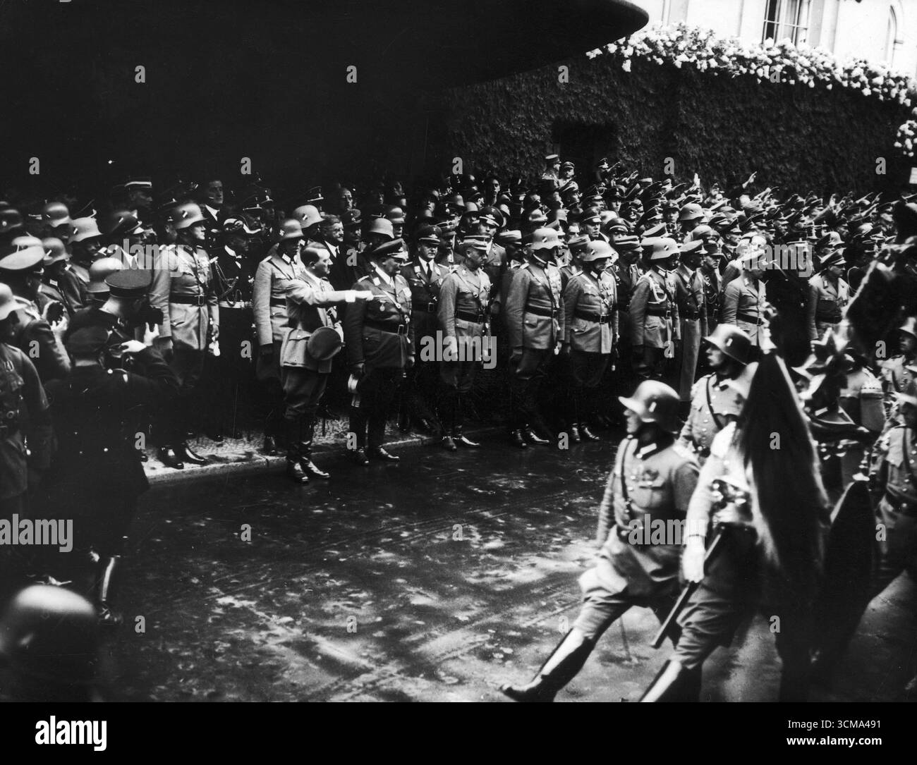 Reich Chancellor Adolf Hitler attends the parade. Visible alongside him ...