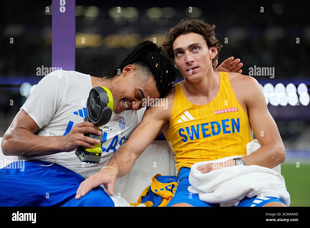 Greece's Emmanouil Karalis holds a portable fan to Sweden's Armand ...