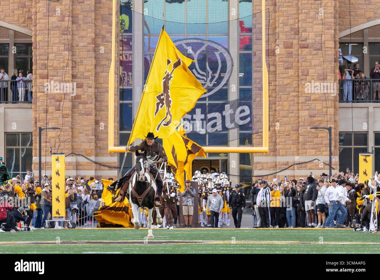 A cowboy horseback carrying the Wyoming Cowboy flag leads the Wyoming ...