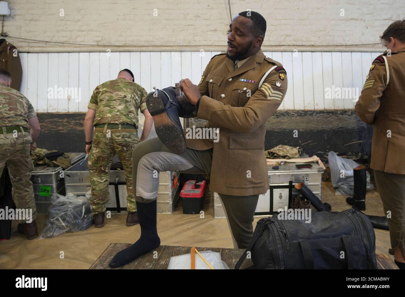 A soldier of Household Cavalry Mounted Regiment brushes his boot at ...