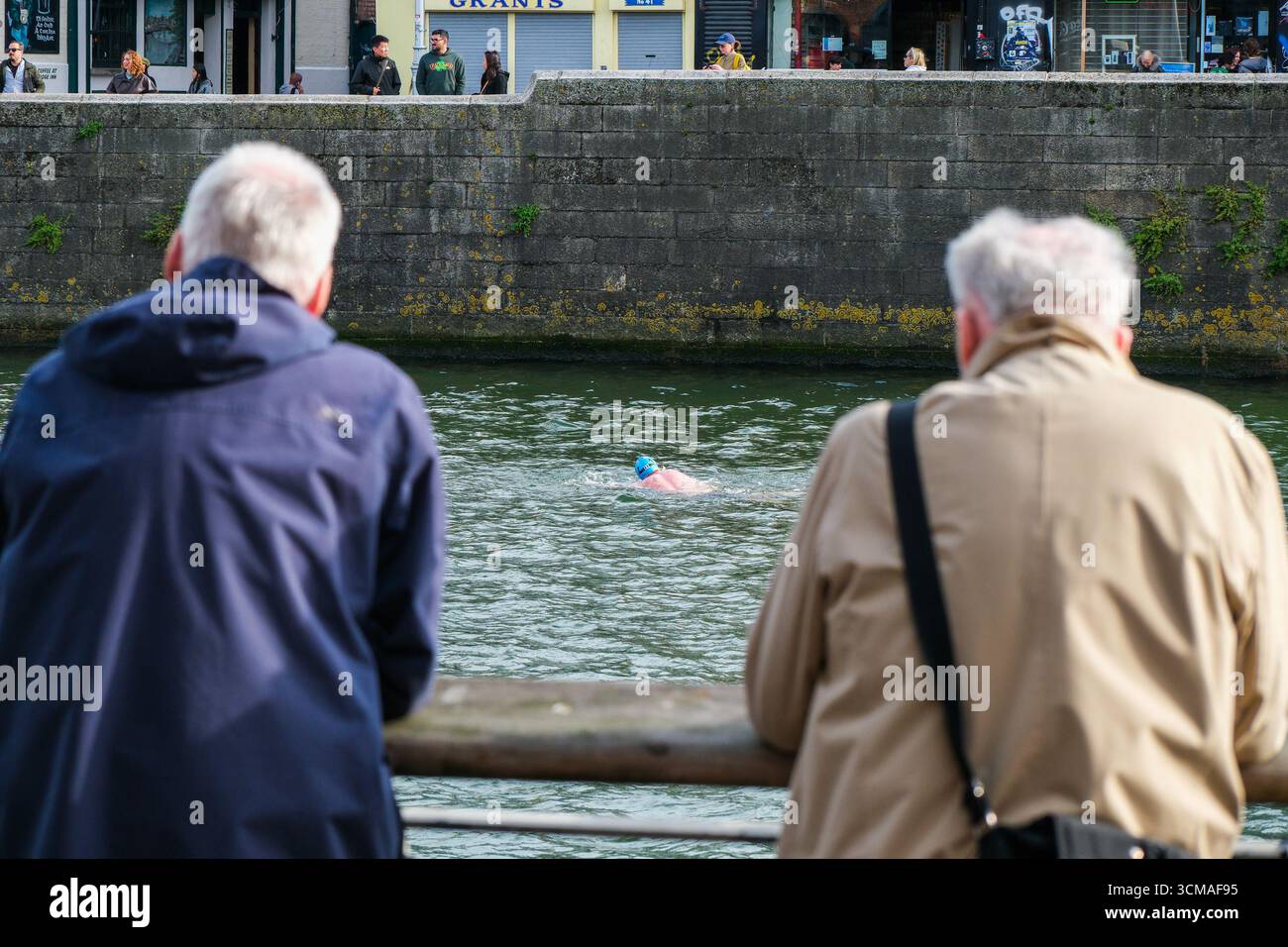 Swimmers swimming in the River Liffey and spectators watching from the ...