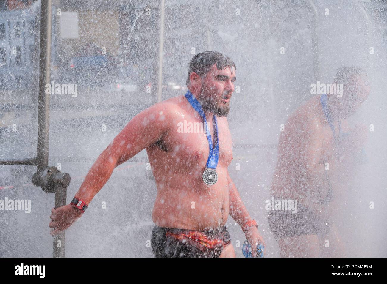 Swimmer washing off in clean water after completing during the 2025 ...