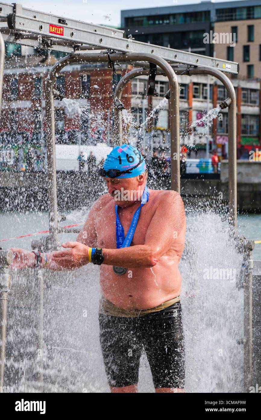 Swimmer washing off in clean water after completing during the 2025 ...