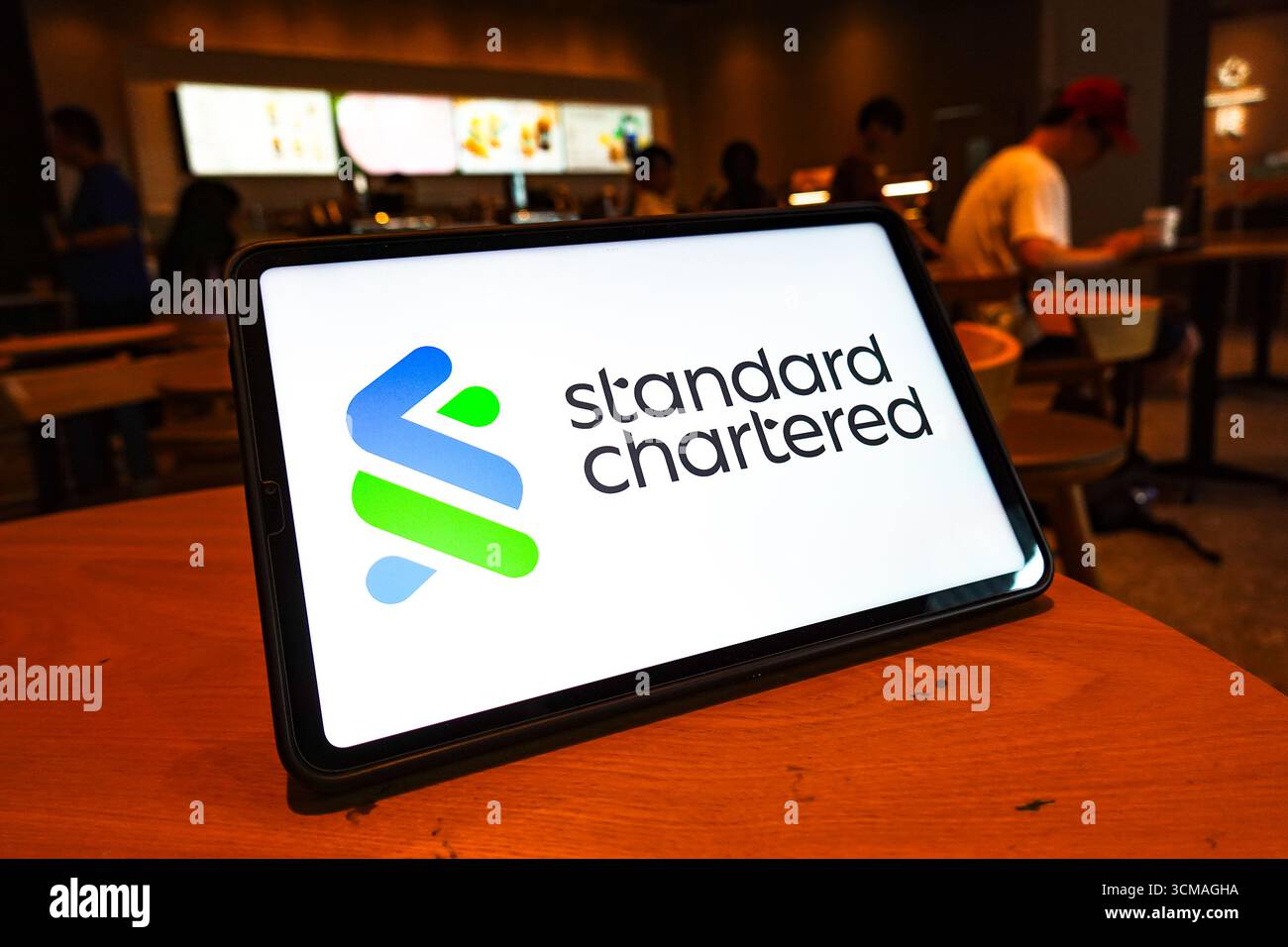 In this photo illustration, the logo of Standard Chartered is displayed ...