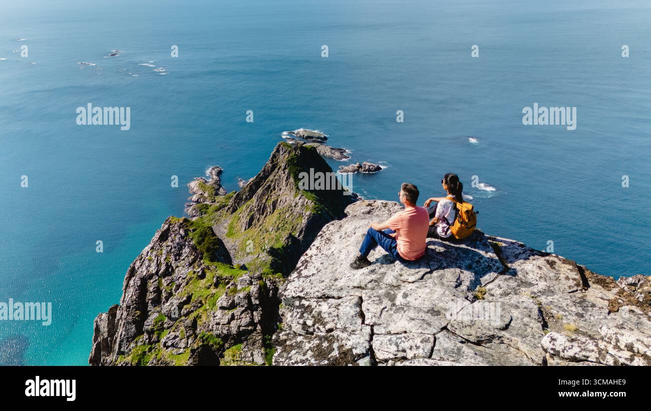 Two adventurers sit atop dramatic hi-res stock photography and images ...