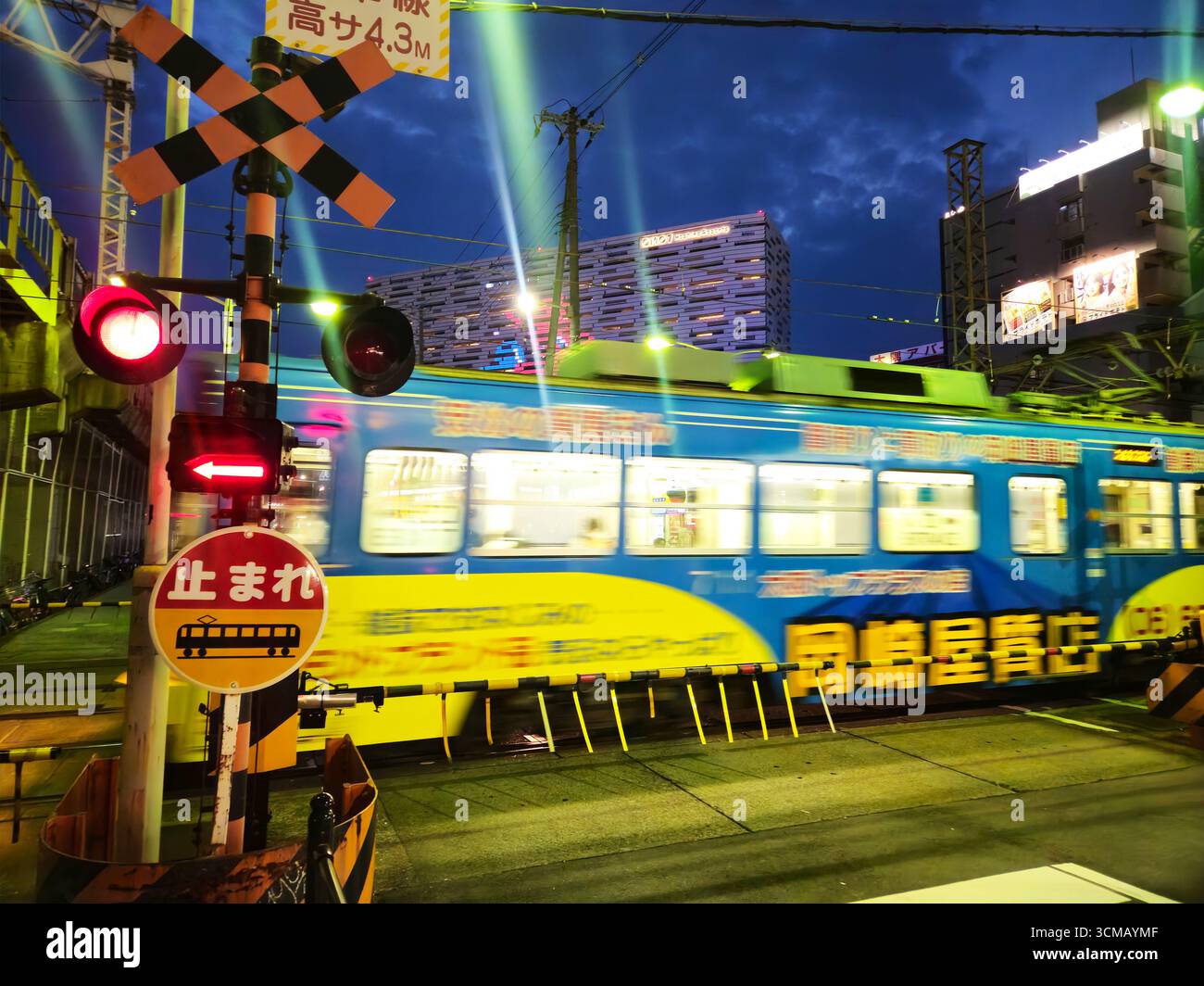Osaka Streetcar Passing a Level Crossing at Dusk Stock Photo - Alamy