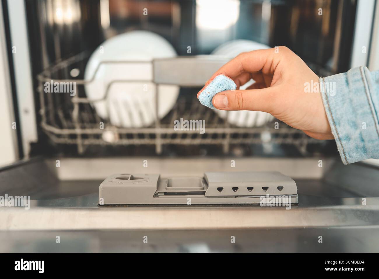 Dishwasher capsule, dishwasher tablets woman puts the capsule in the ...