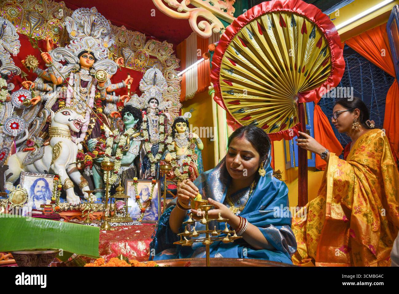 Das Bari housewife traditional bengali dress and lighting a lamp ...