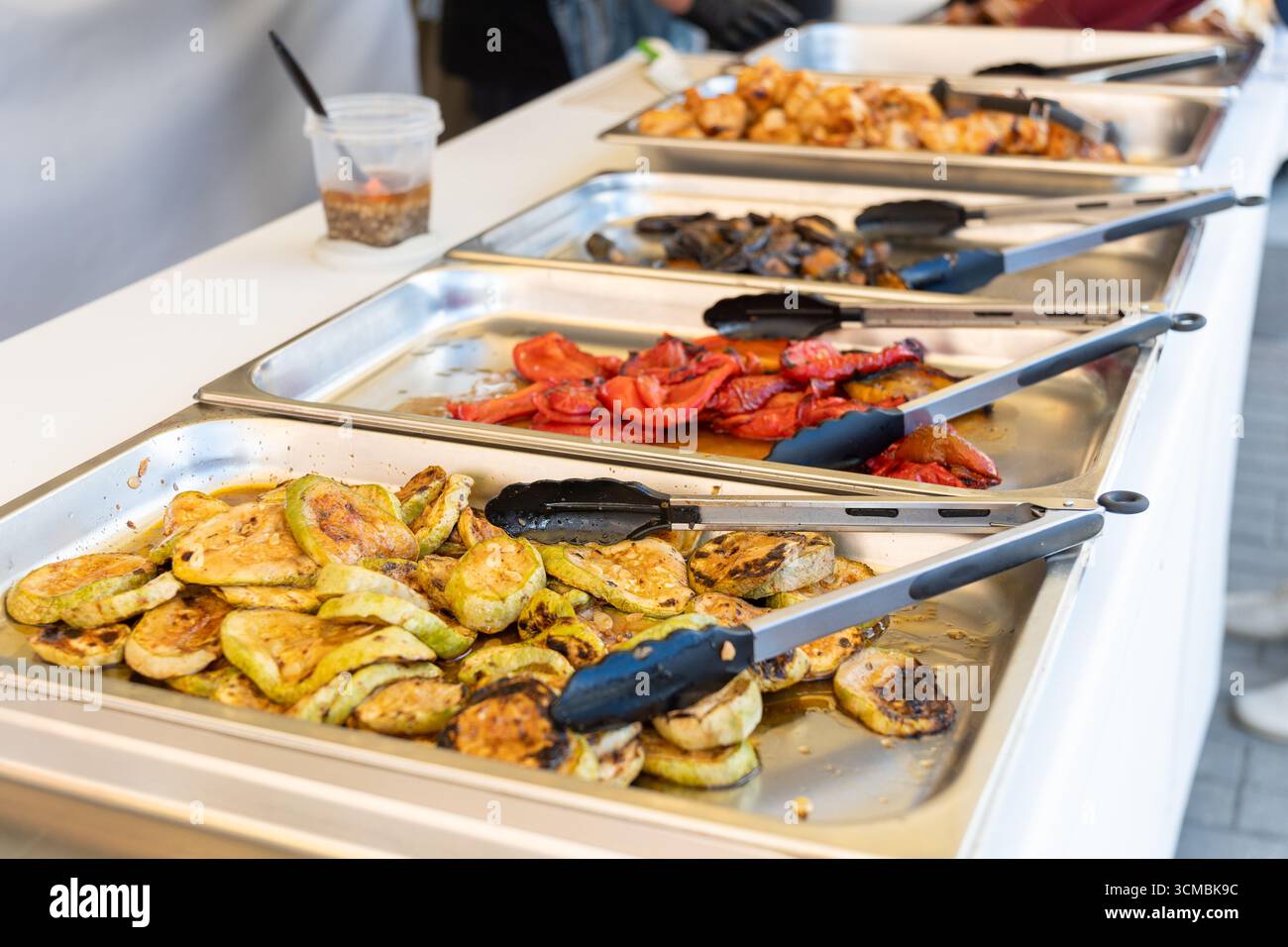 Baked vegetable medley on a buffet: fire-roasted zucchini, bell peppers ...