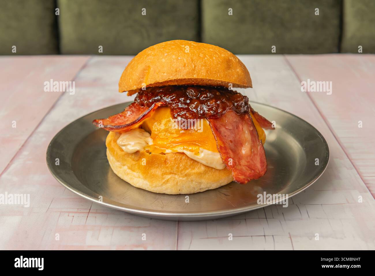 Burger with brioche bun, beef, crispy chicken strips, and buffalo sauce ...