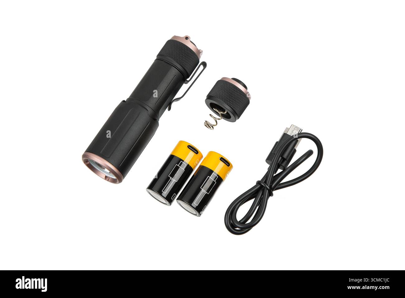 A compact black and copper flashlight disassembled with its batteries ...