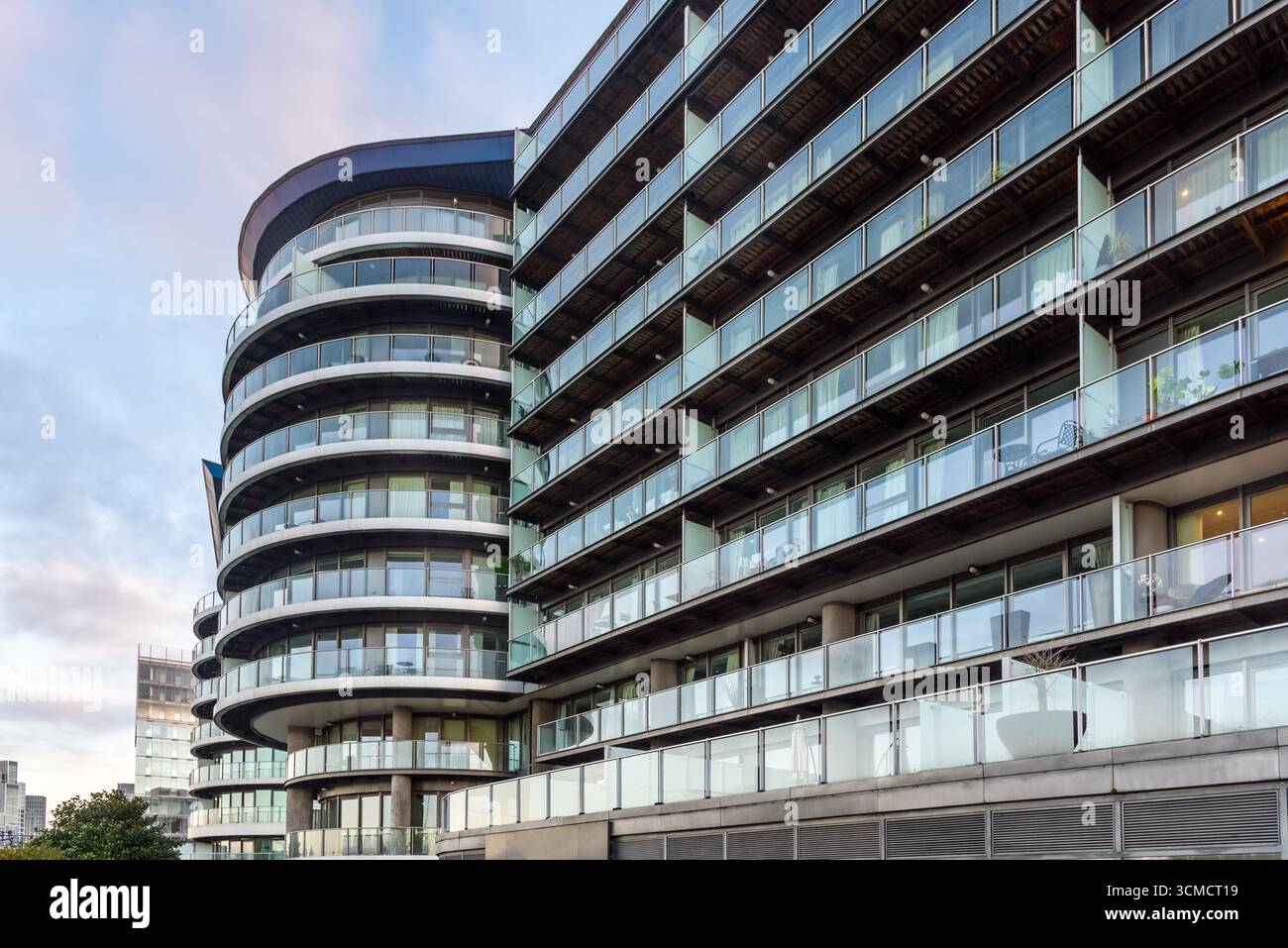 Low angle view of a modern glass apartment building on at dusk in ...