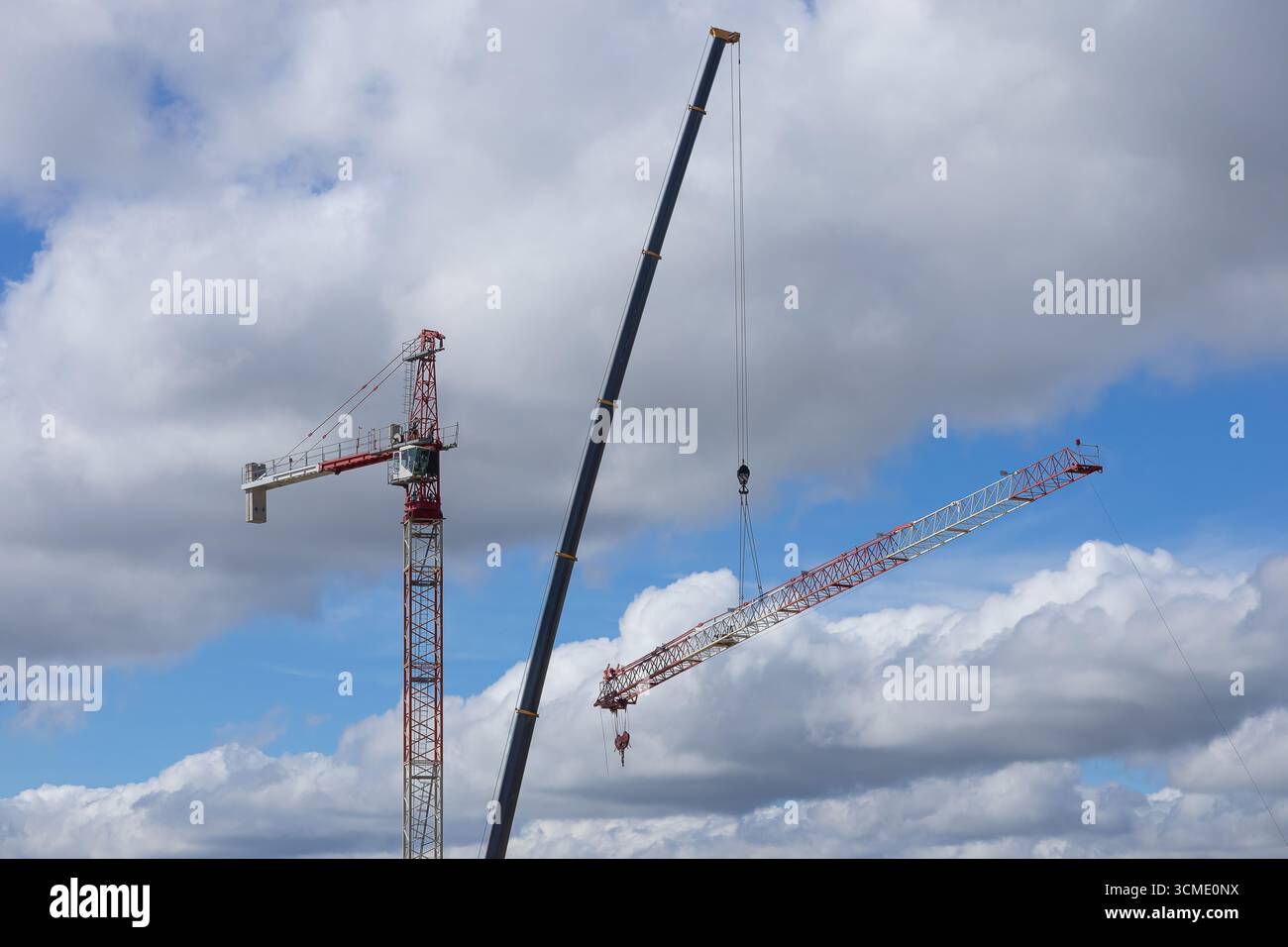 Construction workers using mobile crane to lift and assemble large ...