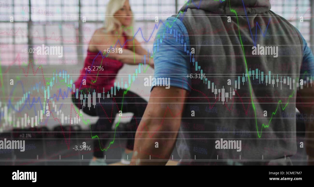 Personal trainer guiding client squatting in gym, with grid glass wall ...