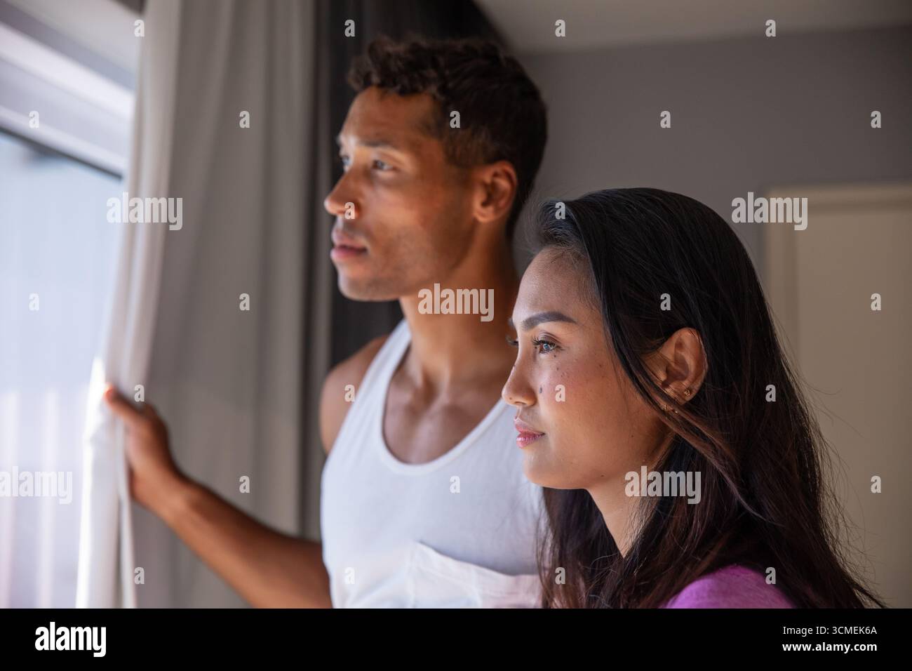 Diverse couple pulling back curtains hi-res stock photography and ...