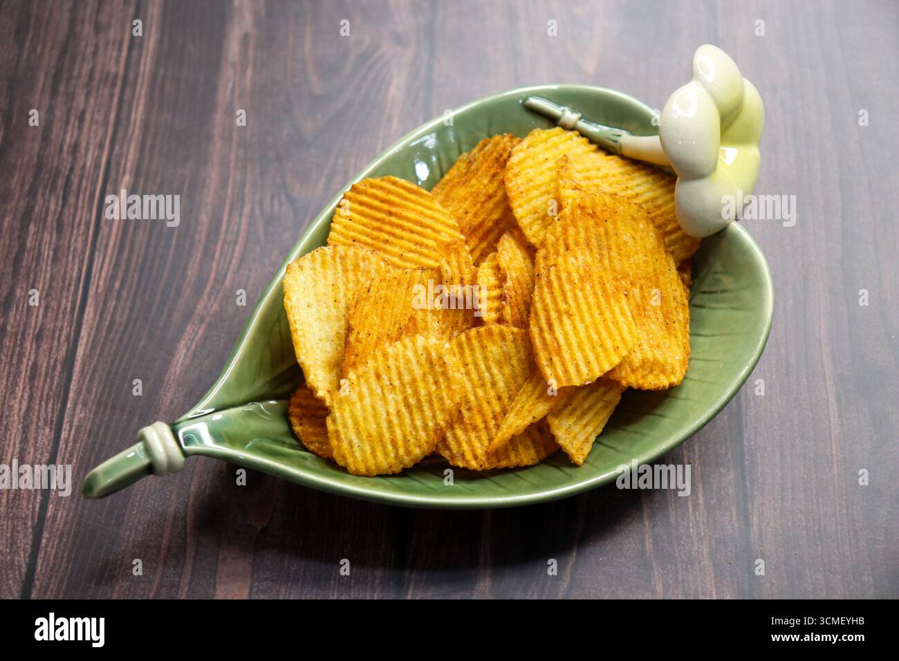 Spicy masala potato chips with golden crisp texture served in a bowl ...