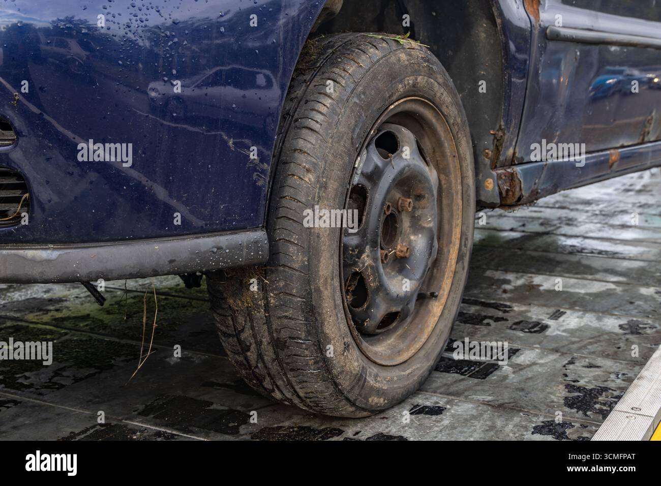 A blue passenger car was wrecked in an accident, with the bumper and ...