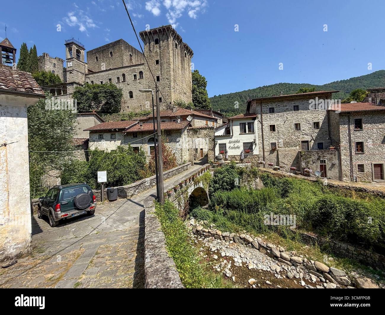 Across the bridge over a narrow river towards the main arch entrance ...