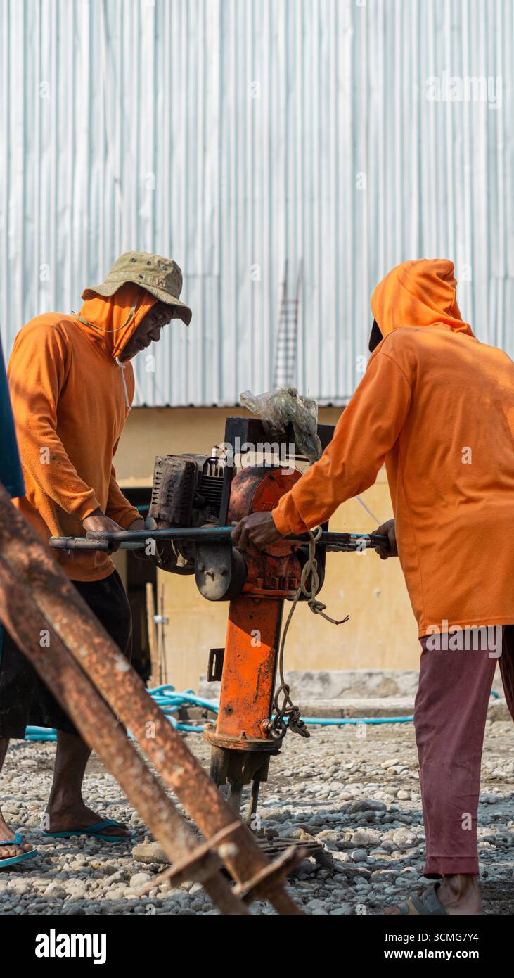 A construction worker operates a soil compactor machine to strengthen ...