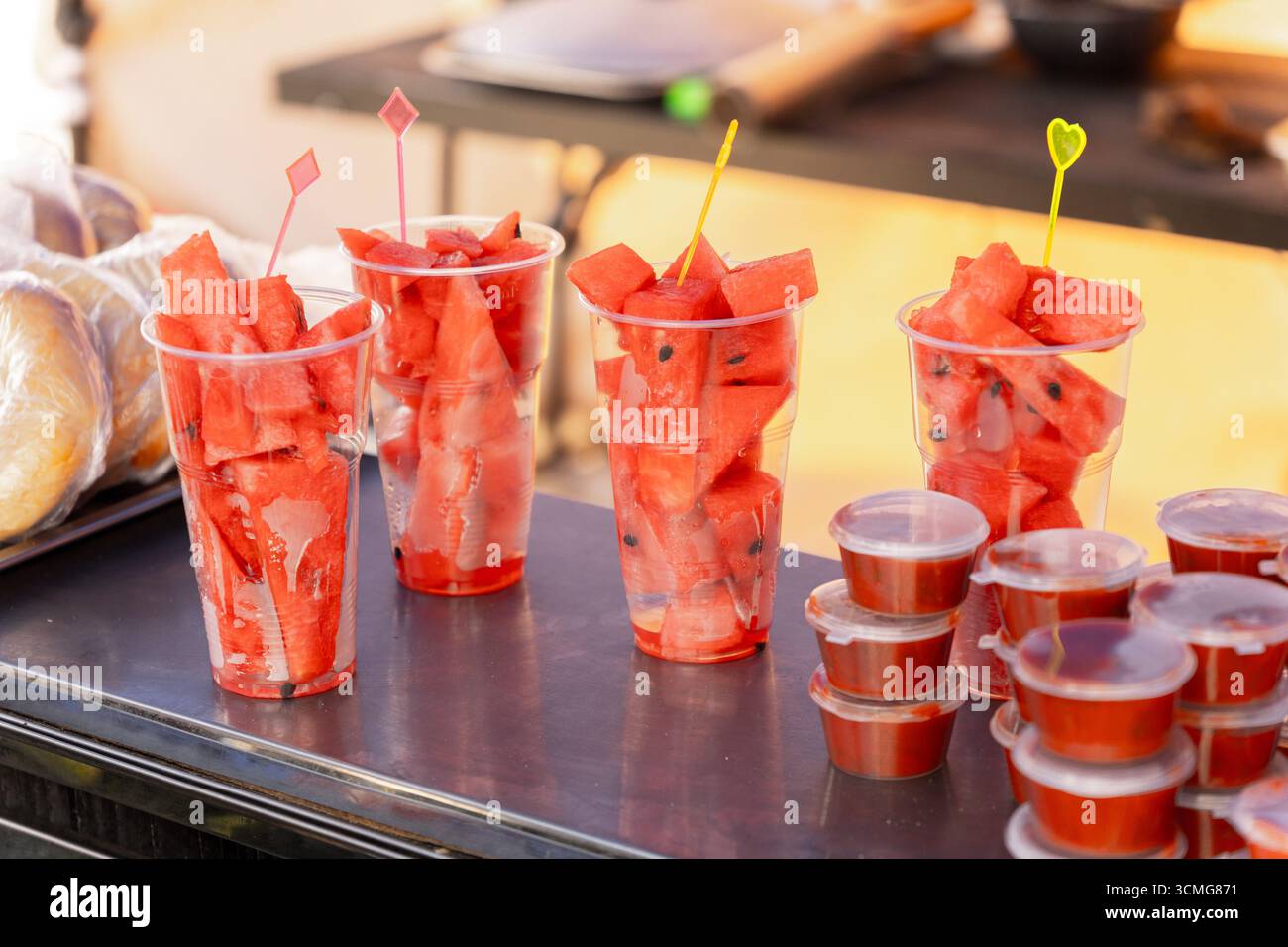Juicy red watermelon chunks portioned in clear plastic cups for ...
