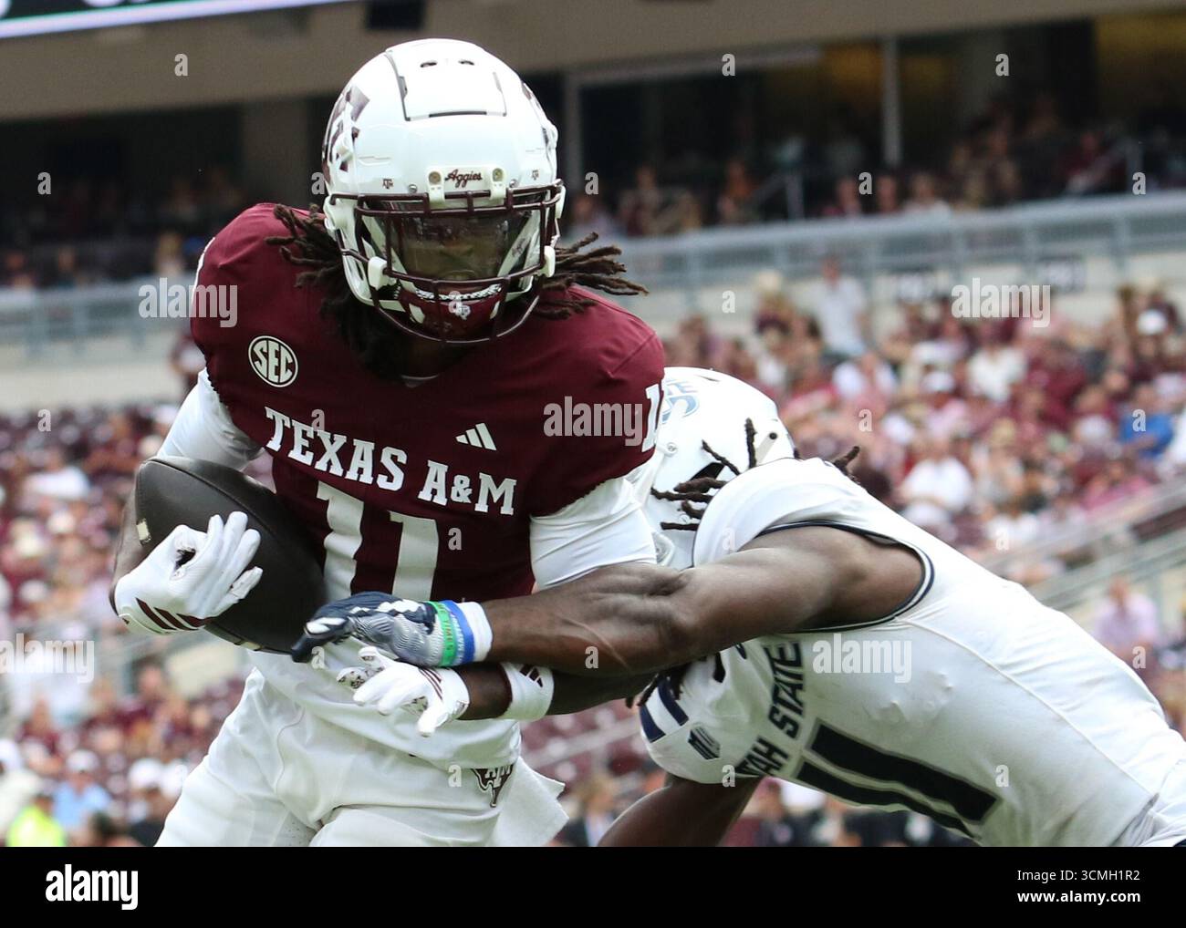 Texas A&M wide receiver Kelshaun Johnson (11) is tackled by Utah State ...