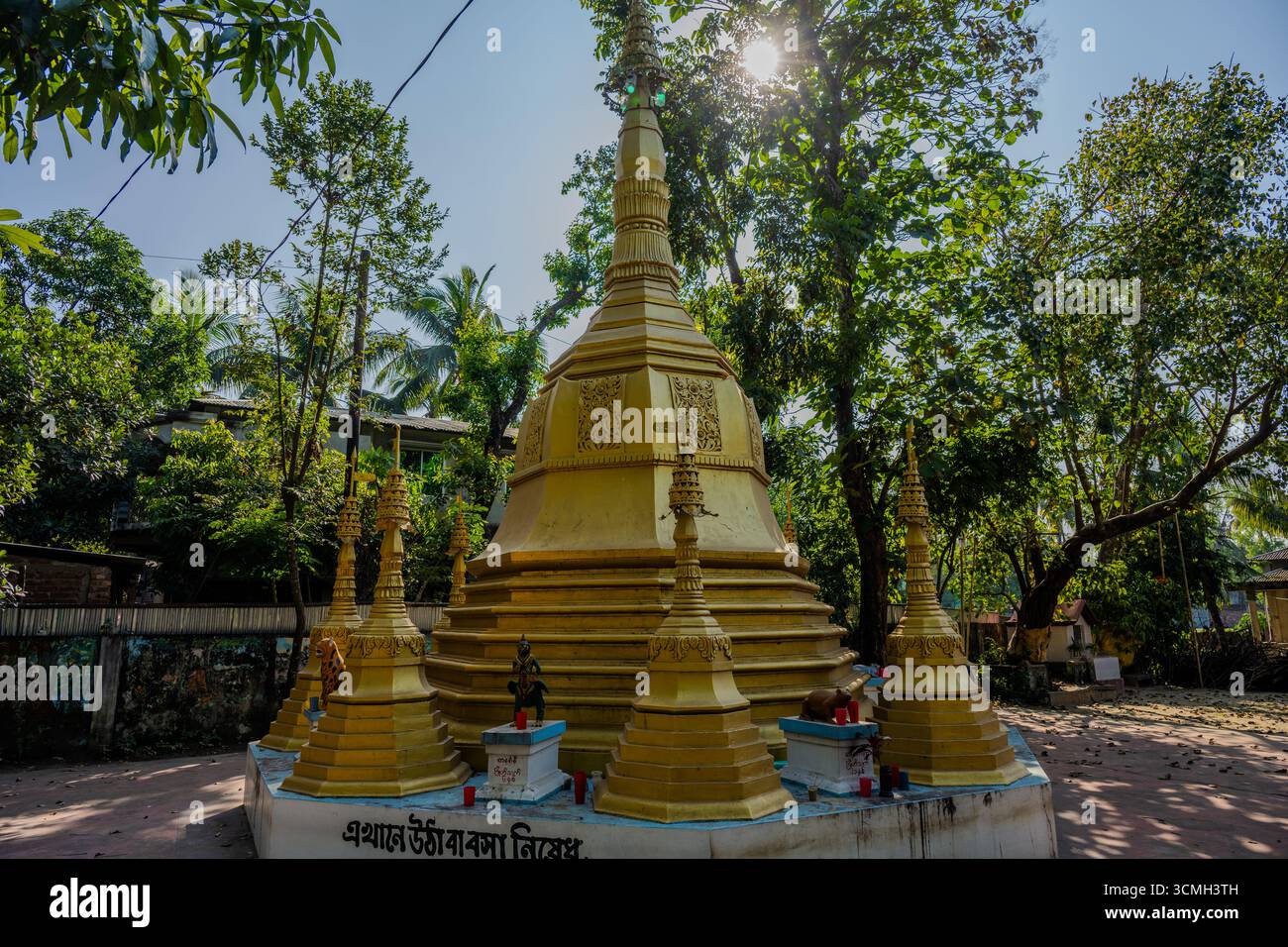 Golden Stupa Surrounded by Smaller Shrines Amidst Lush Greenery at ...