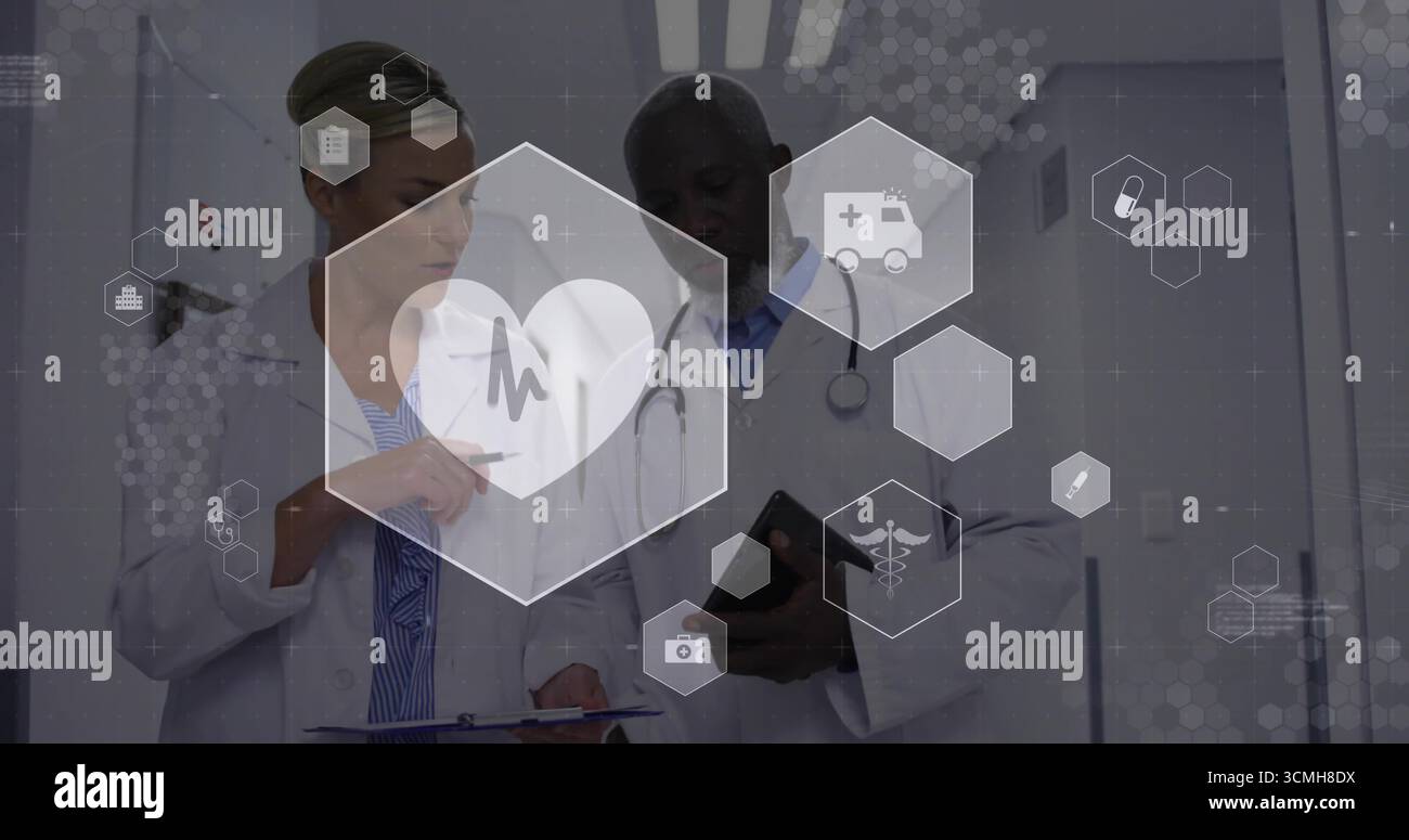 Consulting doctors in lab coats reviewing patient info in hospital ...