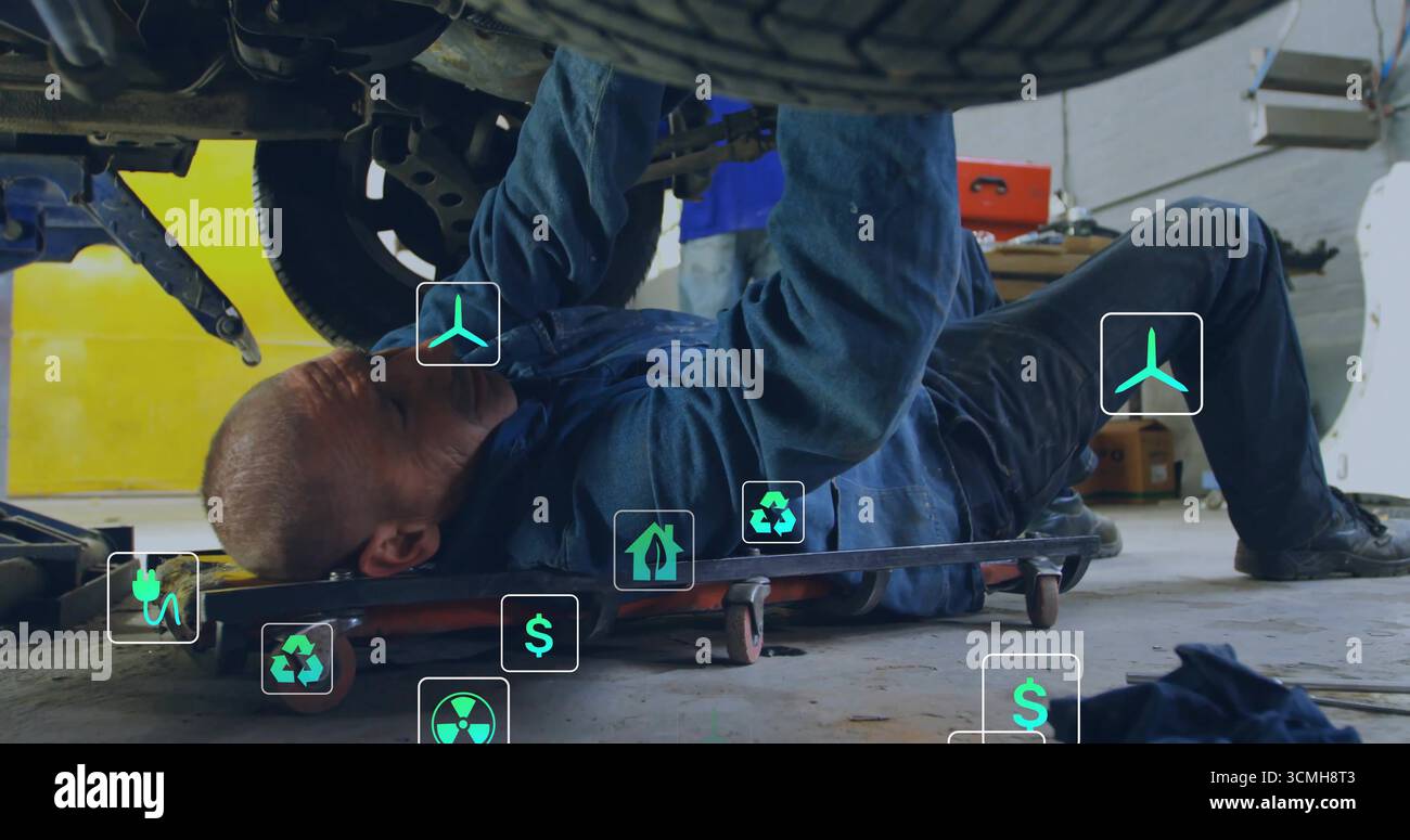 Inspecting mechanic in coveralls examining undercarriage on creeper in ...