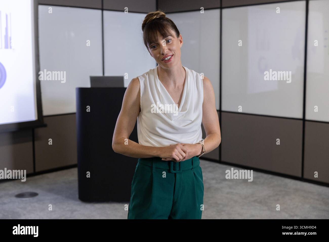 Woman presenter standing at black lectern in meeting room presenting ...