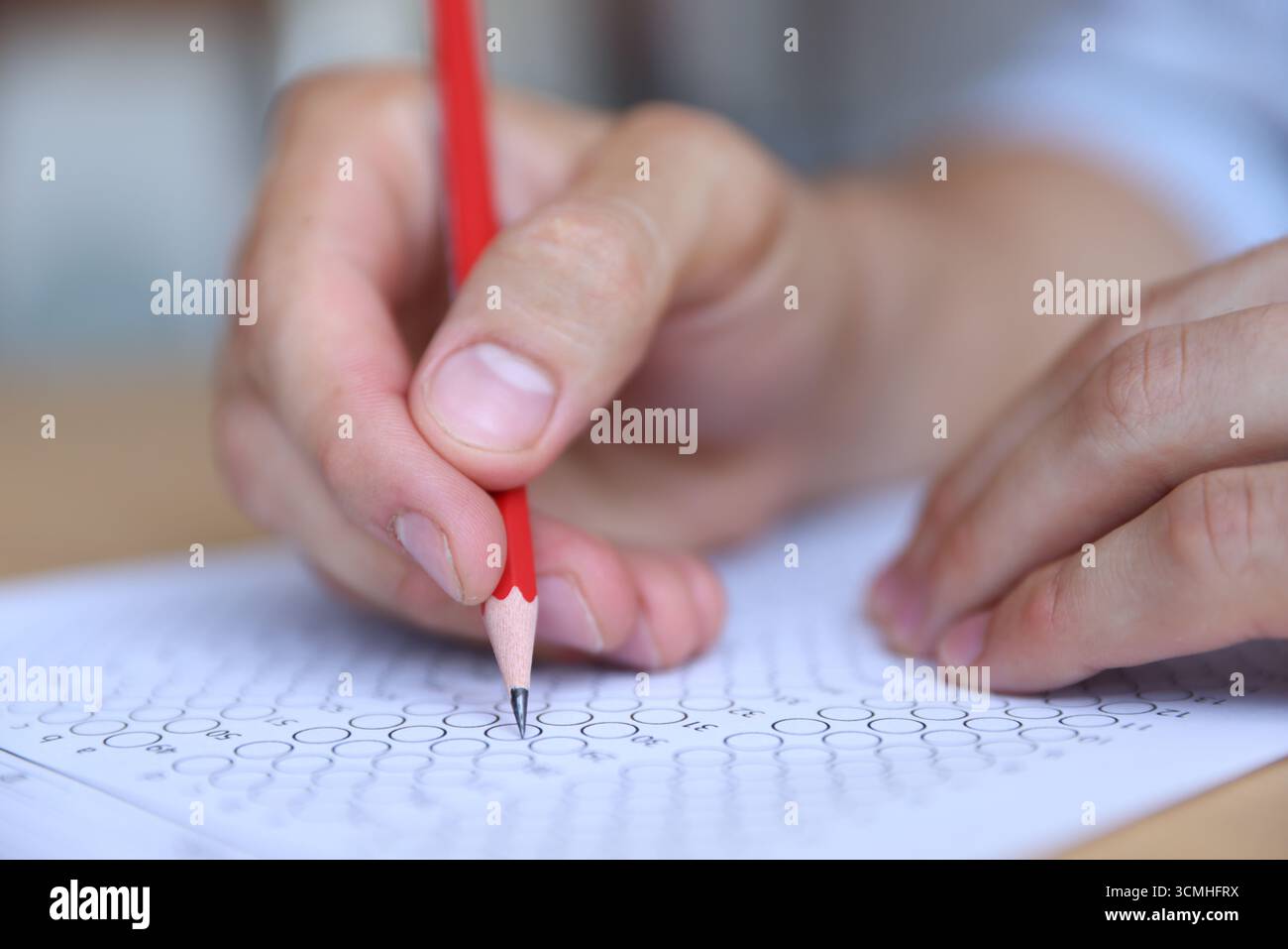 Student filling out multiple choice test at table, closeup. Passing ...